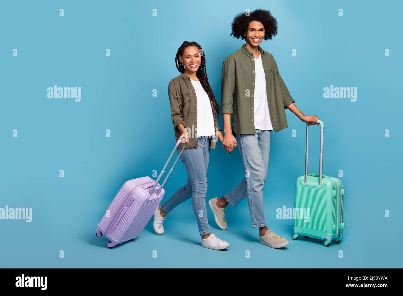 Photo of two friends spouses step check in terminal hold luggage weekend wear shirt jeans ...