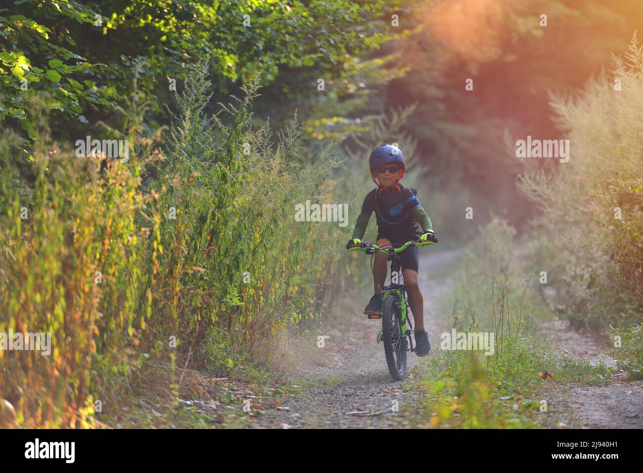 Happy kid boy of 8 years having fun in autumn park with a bicycle on ...