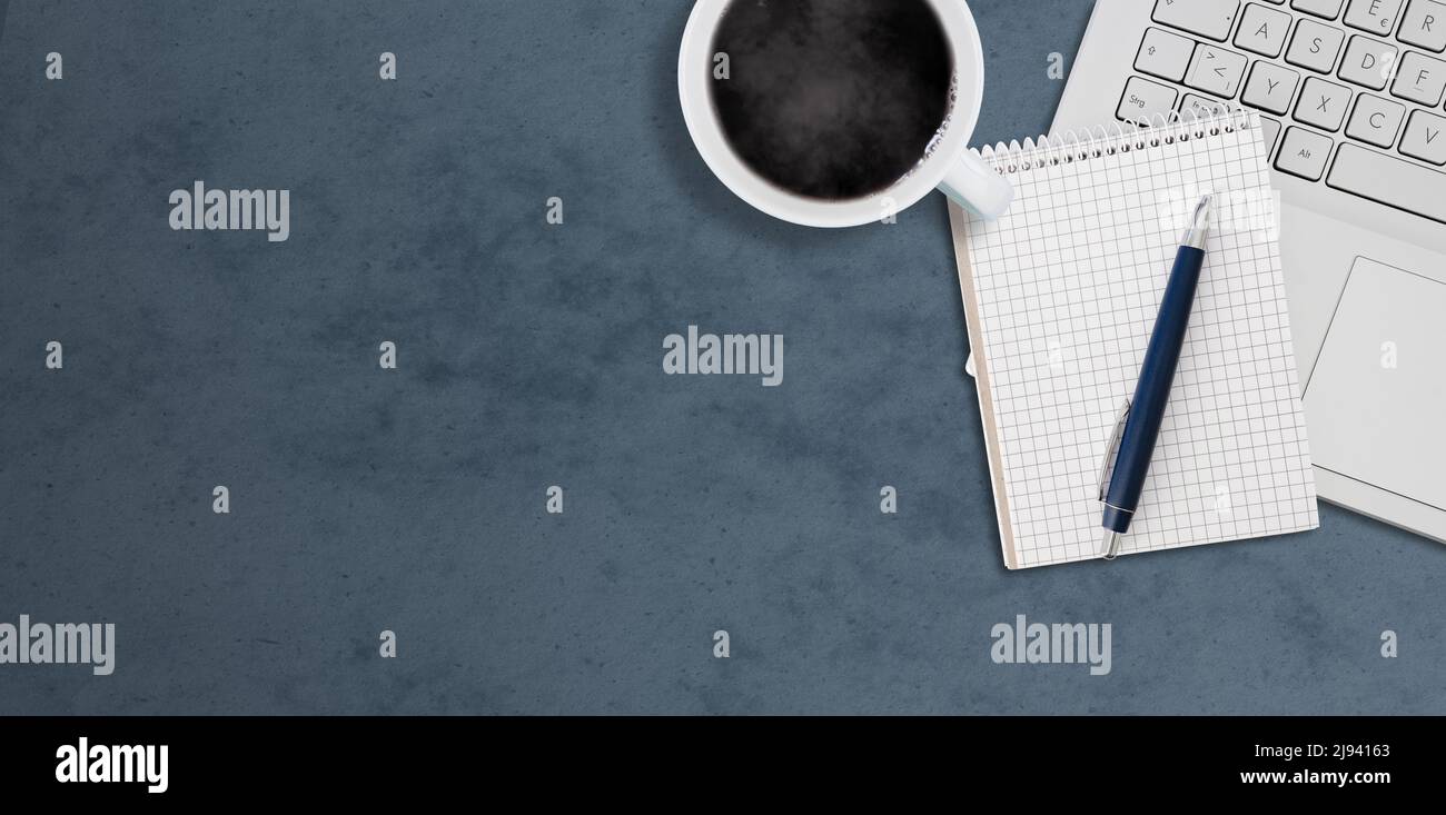 top down view of laptop computer, coffee cup and notepad with pen on ...