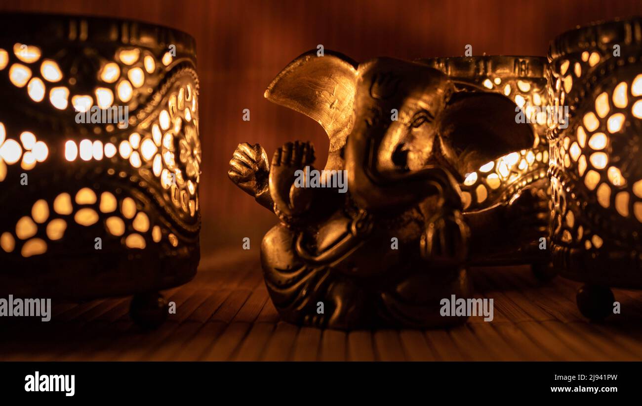 Golden ganesha figure with warm candle light. Meditation and worship ...