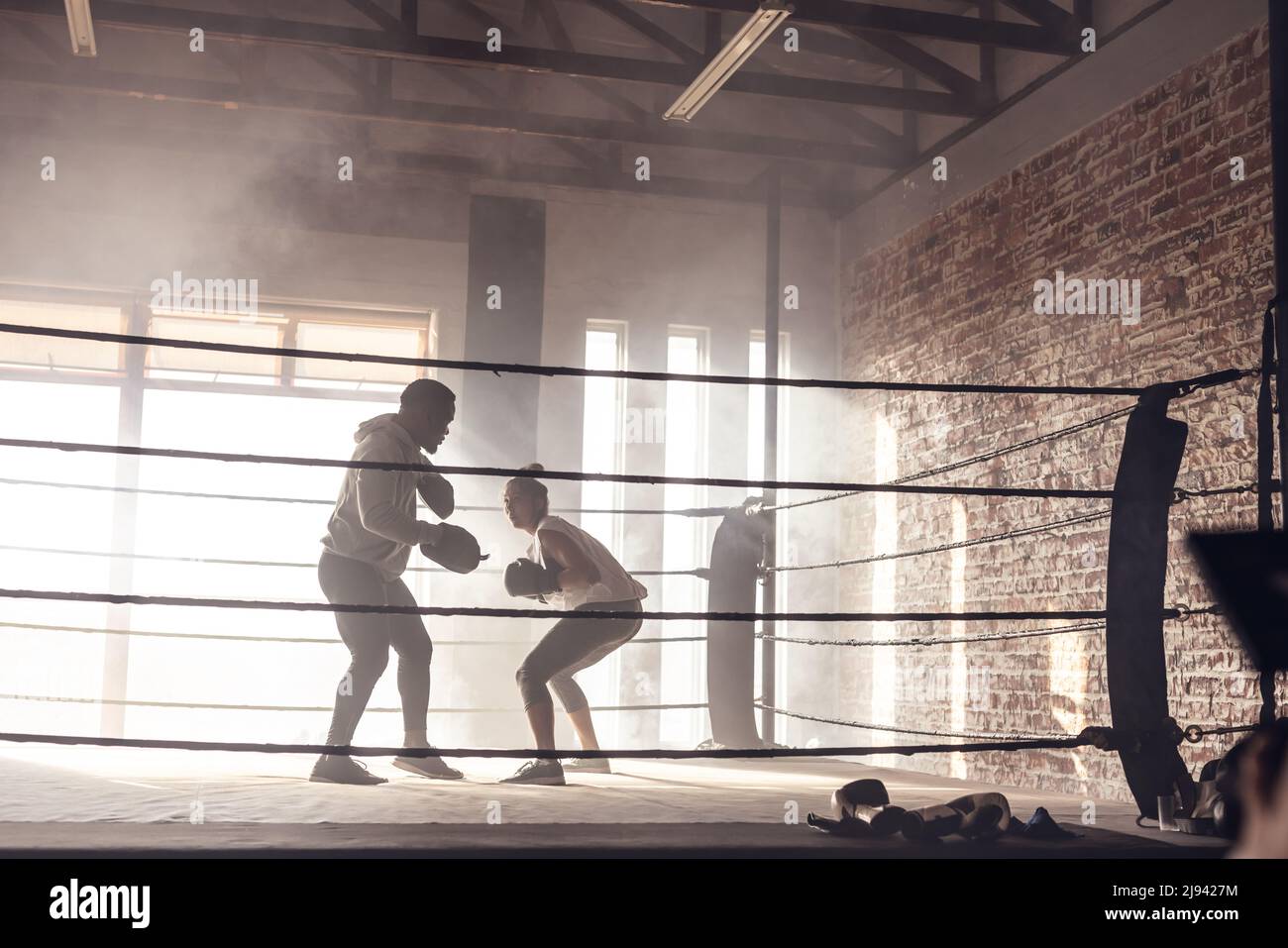 Caucasian young female boxer practicing boxing with african american ...