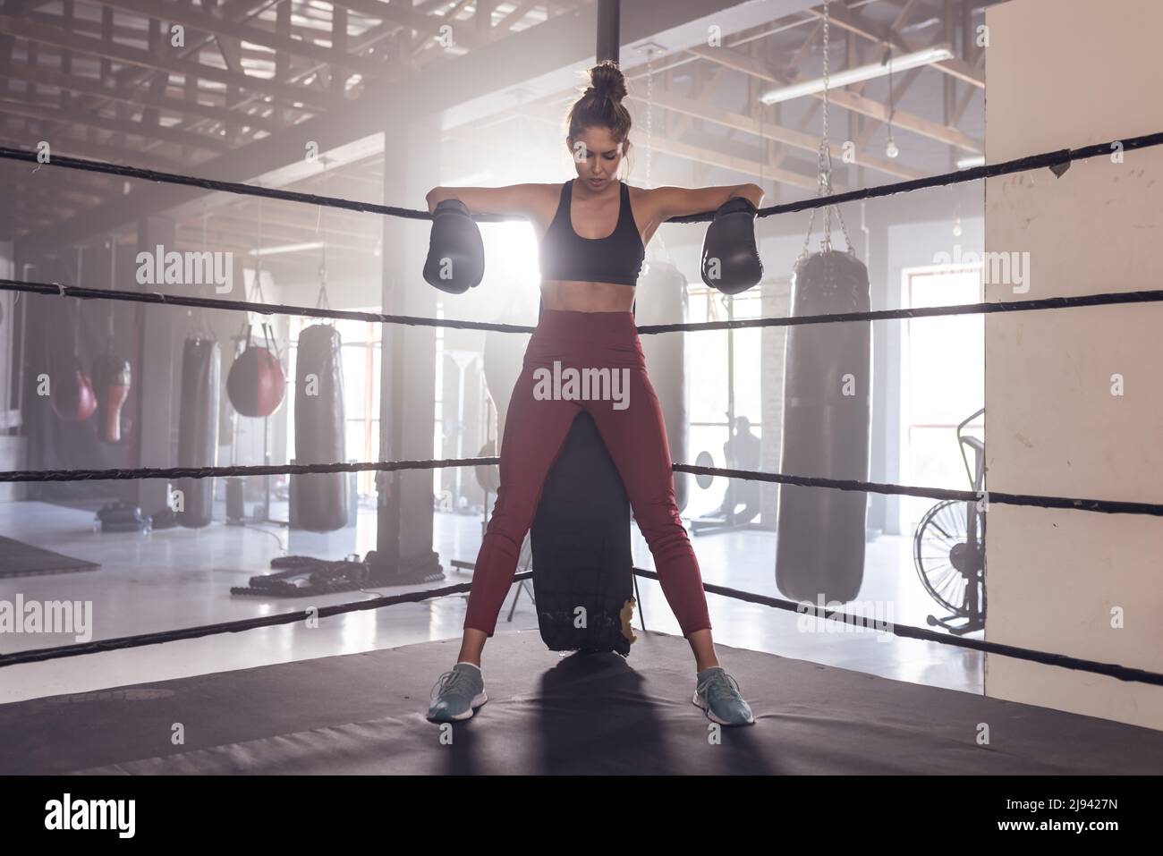 Full length of tired caucasian young female boxer wearing gloves ...