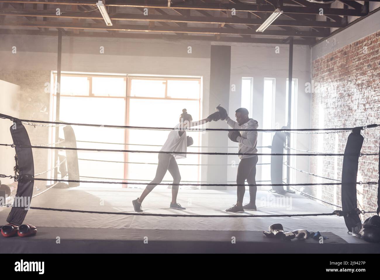 African american male coach giving boxing training to caucasian young ...