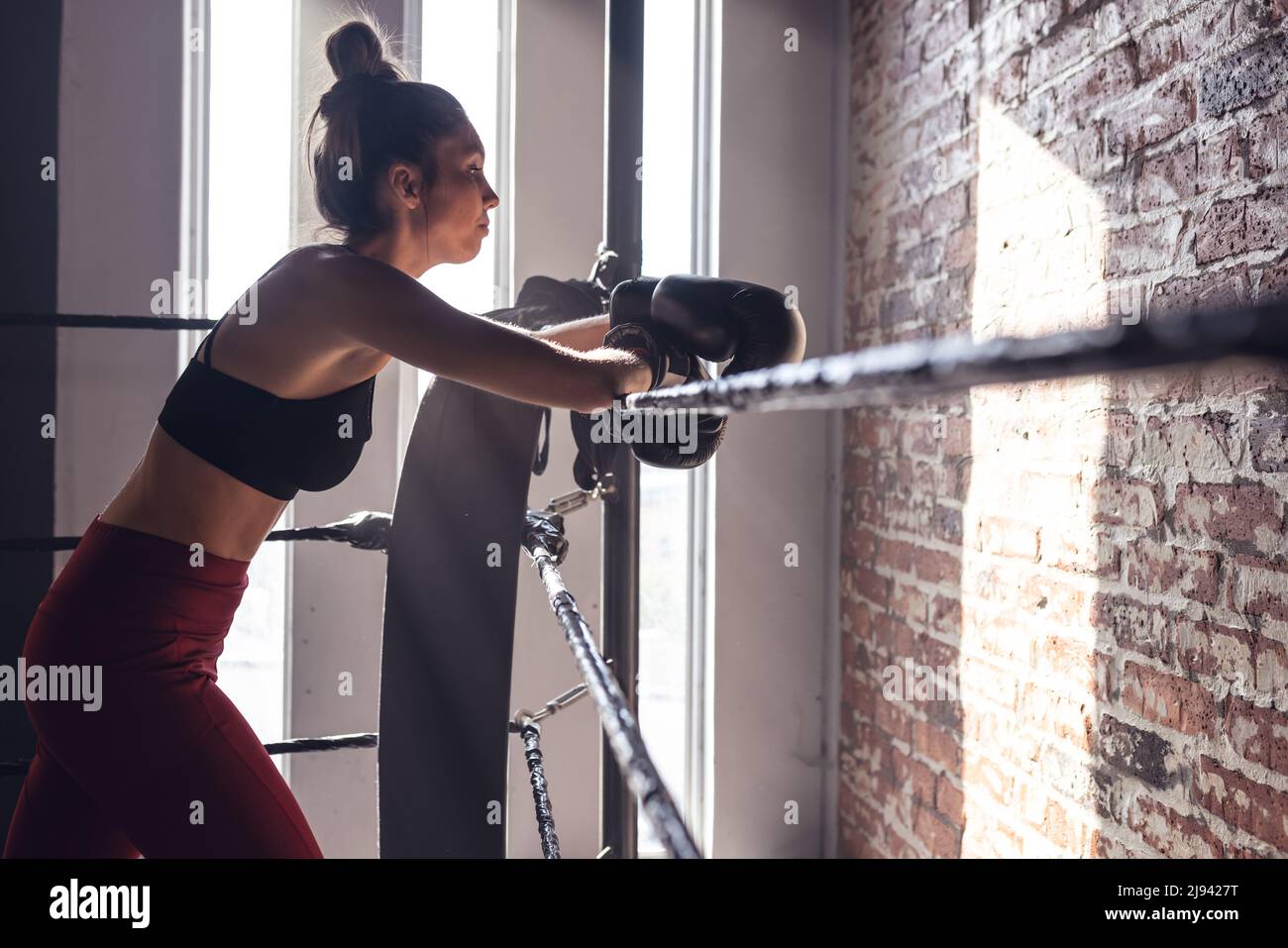Side view of caucasian young female boxer contemplating while standing ...