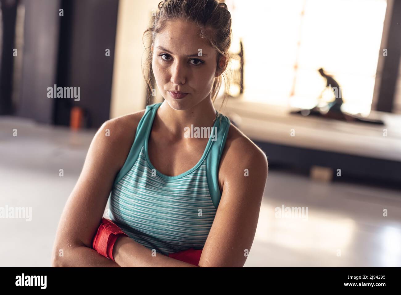 Portrait of confident caucasian young female boxer with arms crossed ...