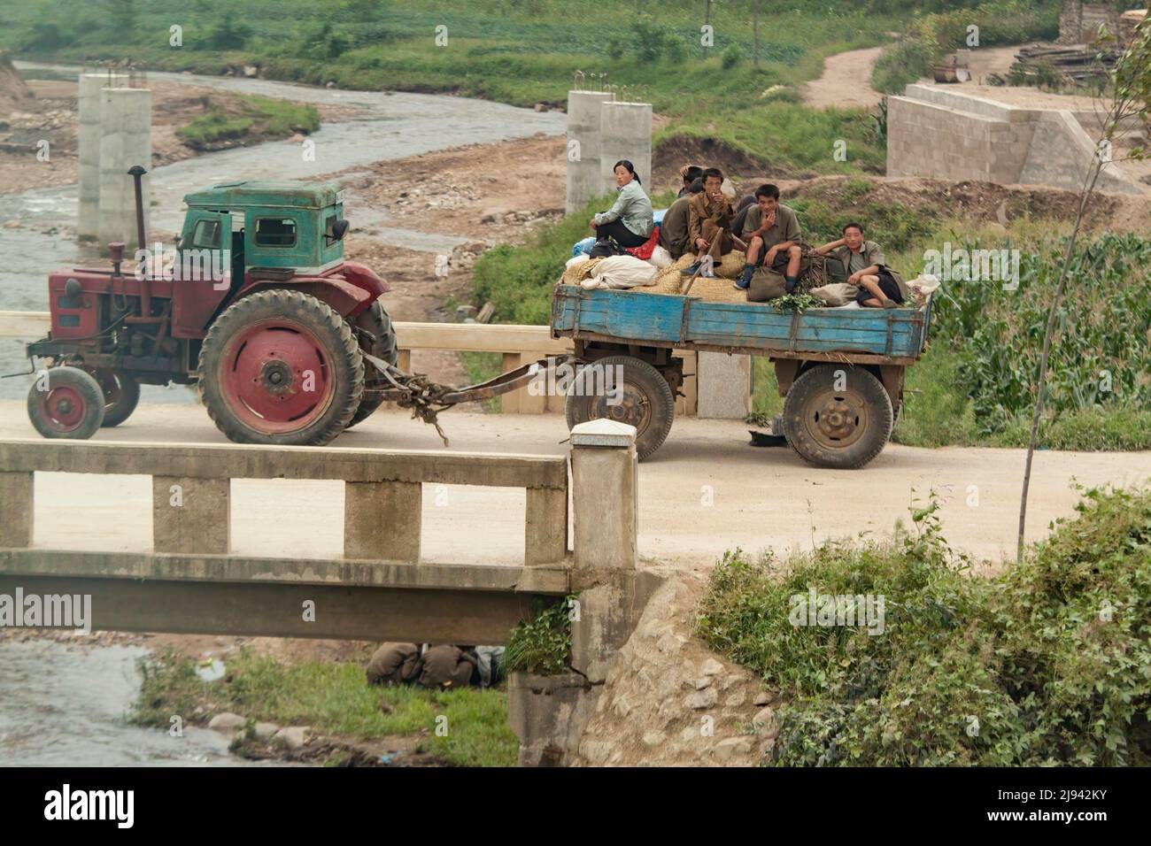 Tractor carrying rice harvest and farmers to agricultural commune, Amdu ...