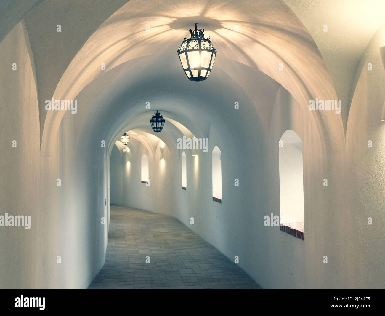 Castle corridor lightened with overhead lighting. Interior of a long ...