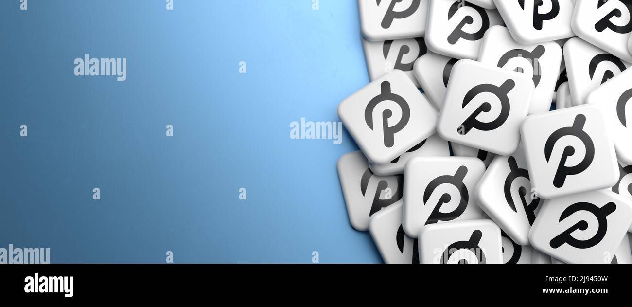 Logos of the exercise equipment company Peloton Interactive on a heap ...
