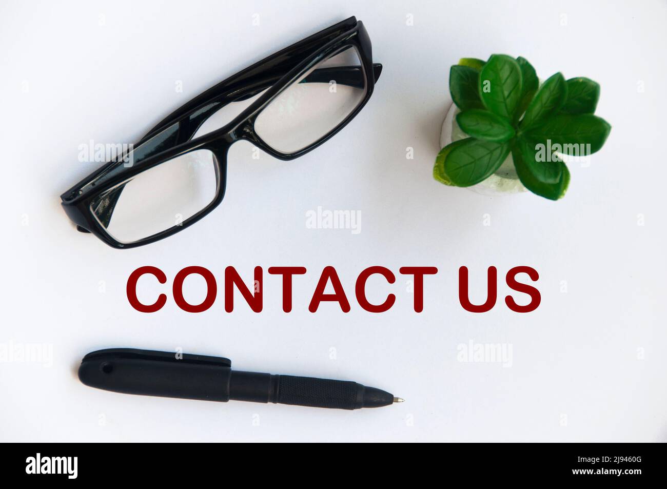 Top view of contact us text on white cover background with glasses ...
