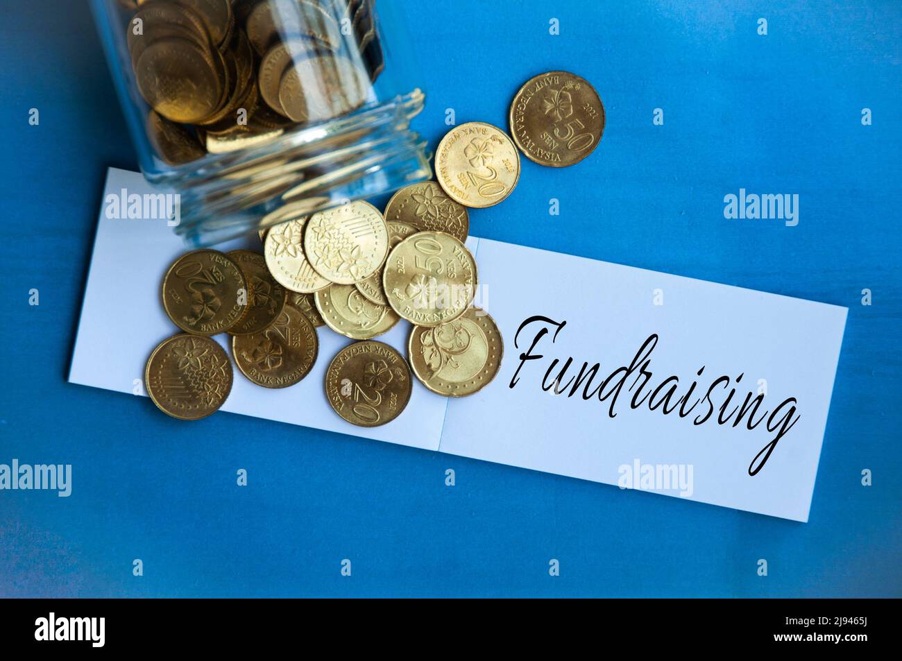 Fundraising text on notepad with gold coins on blue background Stock ...