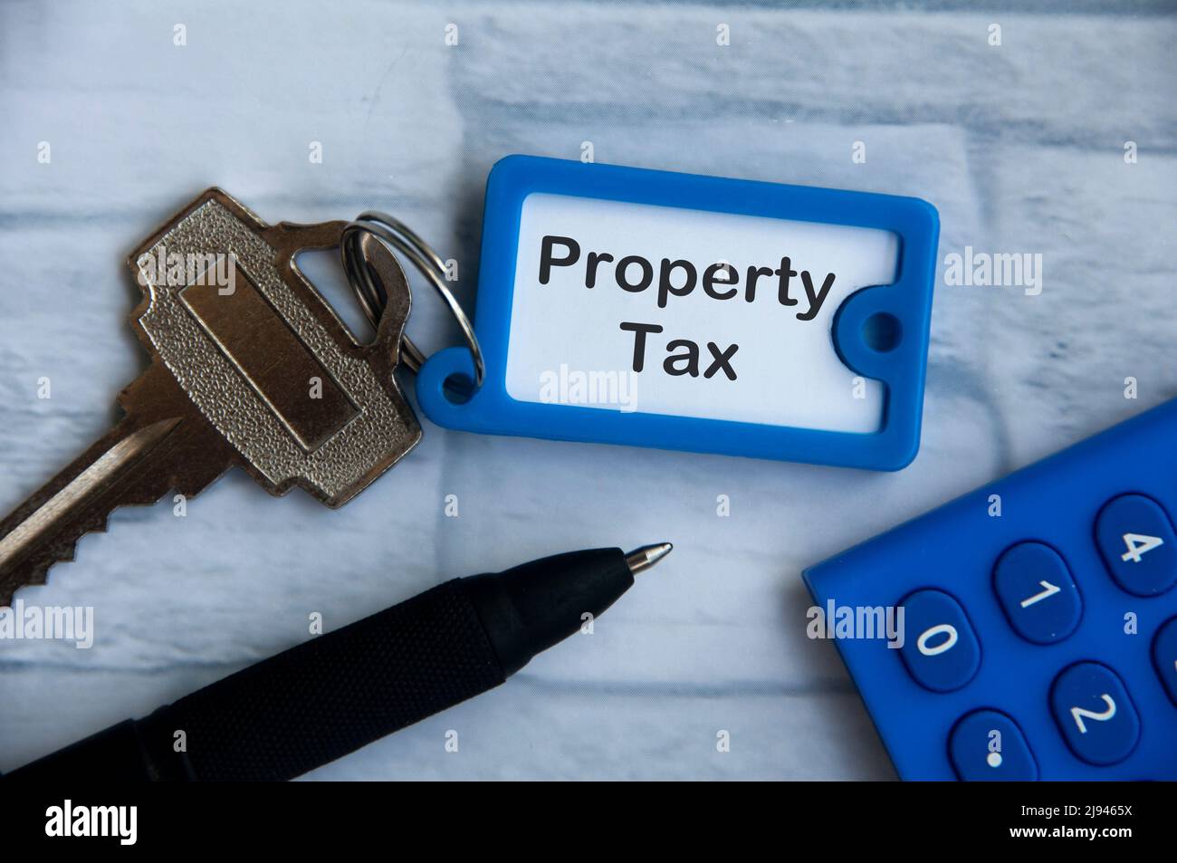 Property tax labeled on keychain with pen and calculator background ...