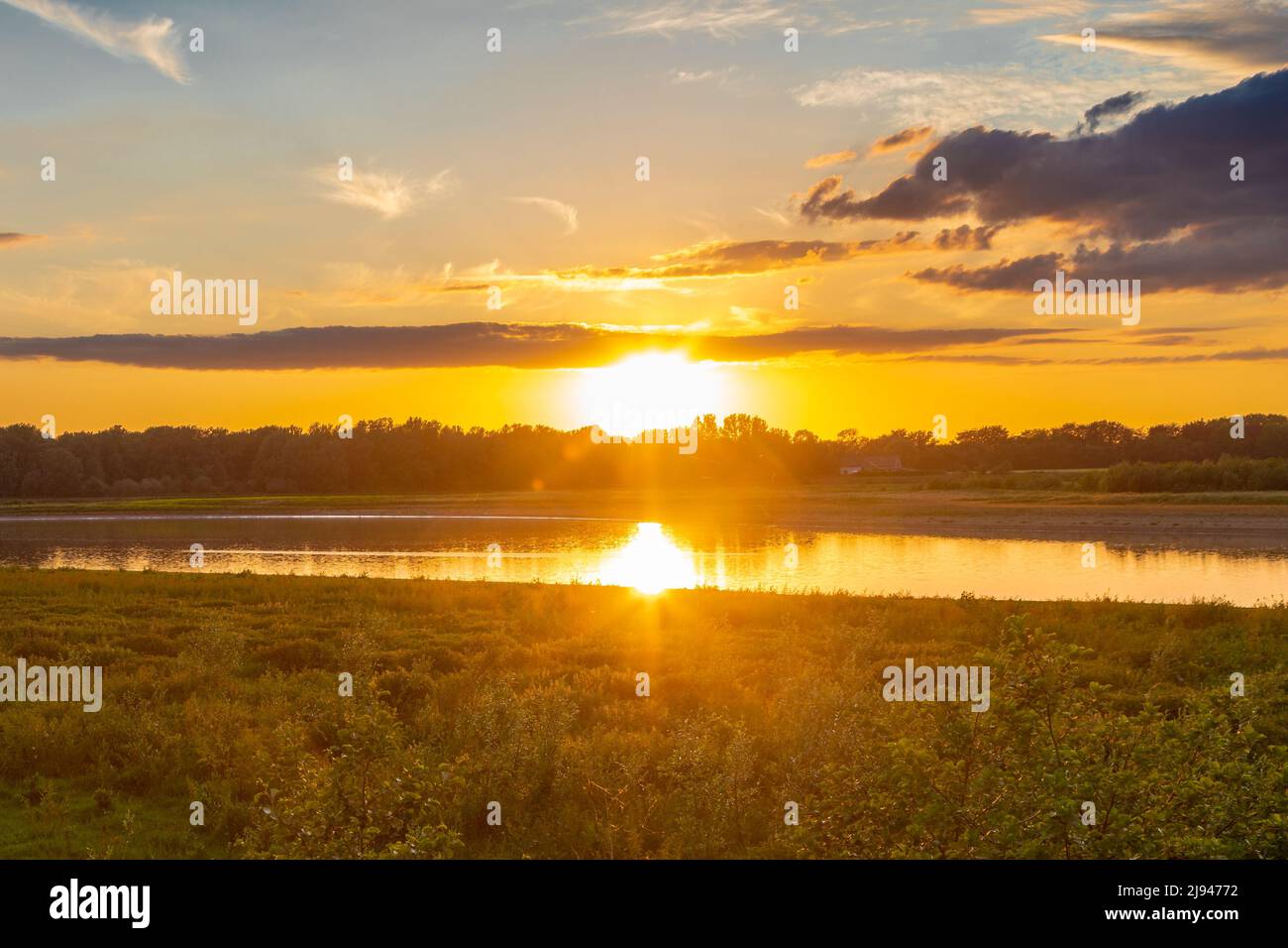 Beautiful sunset full of colors and dramatic clouds at the border ...