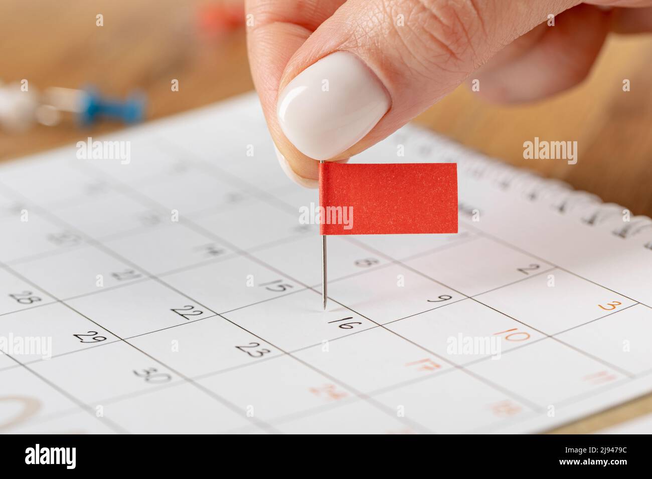 Hands fixing notes schedule, red flag pin thumbnail in calendar for ...