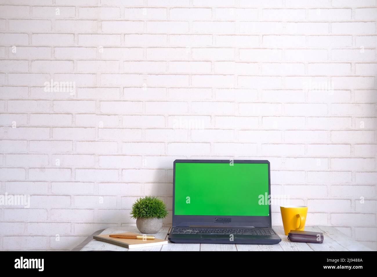 laptop with blank screen on office desk. against a wall Stock Photo - Alamy