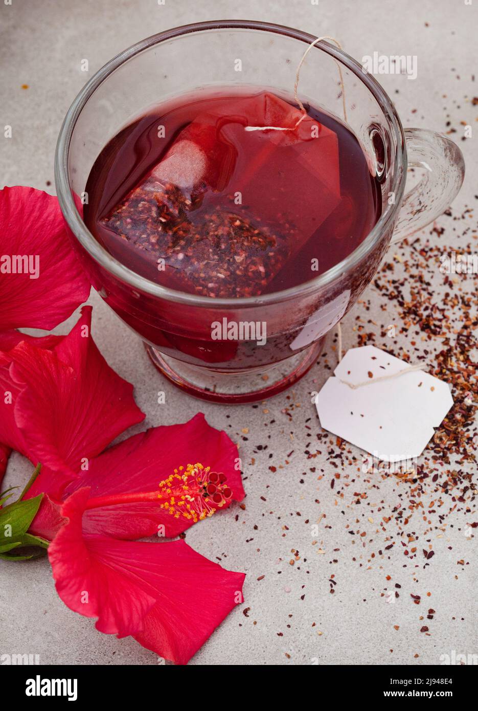 Bright and flavorful hibiscus tea in a glass cup, with hibiscus flower ...