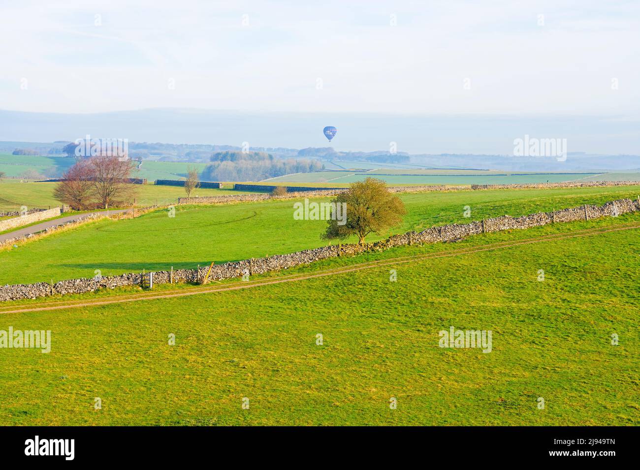 A misty morning near Matlock, Derbyshire, a hot air balloon rises from ...