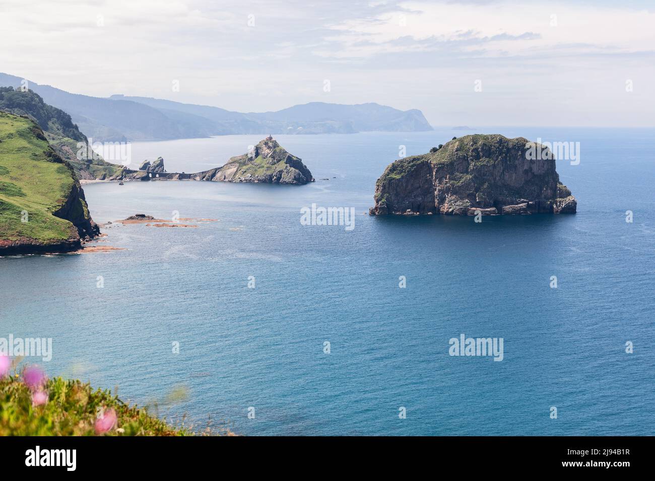 Shallow bay with two small islands Gaztelugatxe and Aketx, and endless ...