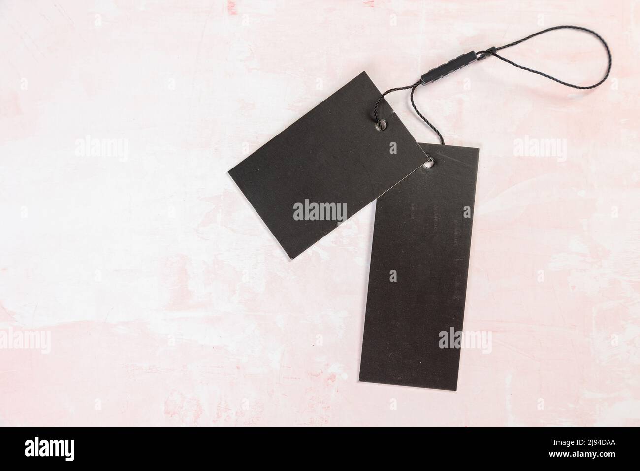 Clothing tag, label blank mockup template on a pink table Stock Photo ...