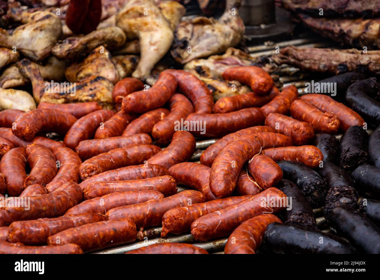 red sausages and black pudding on a grill. Meat-based food cooked on ...