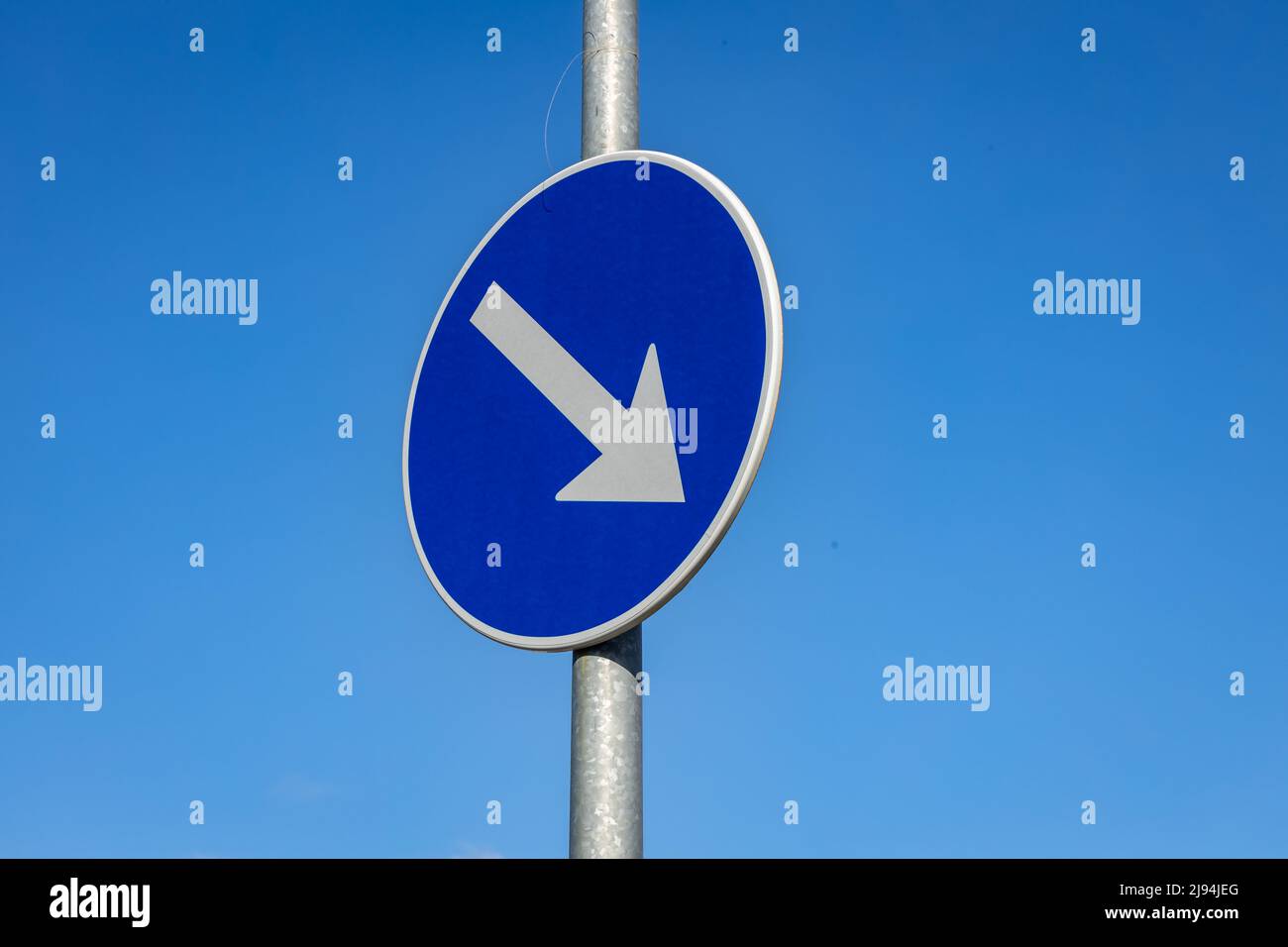 Traffic sign with a white arrow. Lane signaling. Sign mounted on an ...