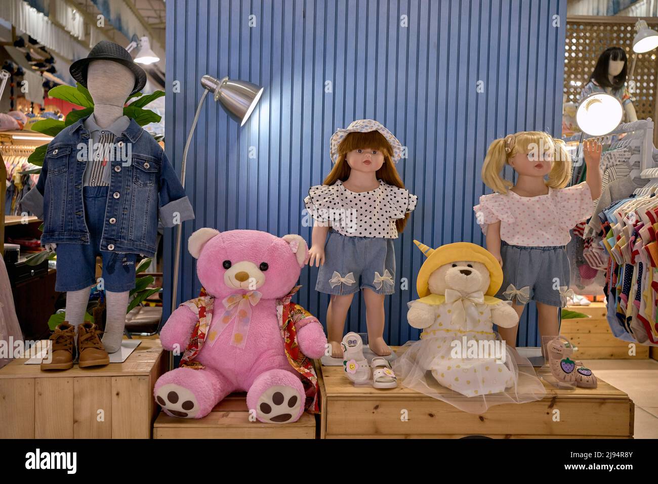 Children's clothing shop display with soft toys and dolls modelling the ...