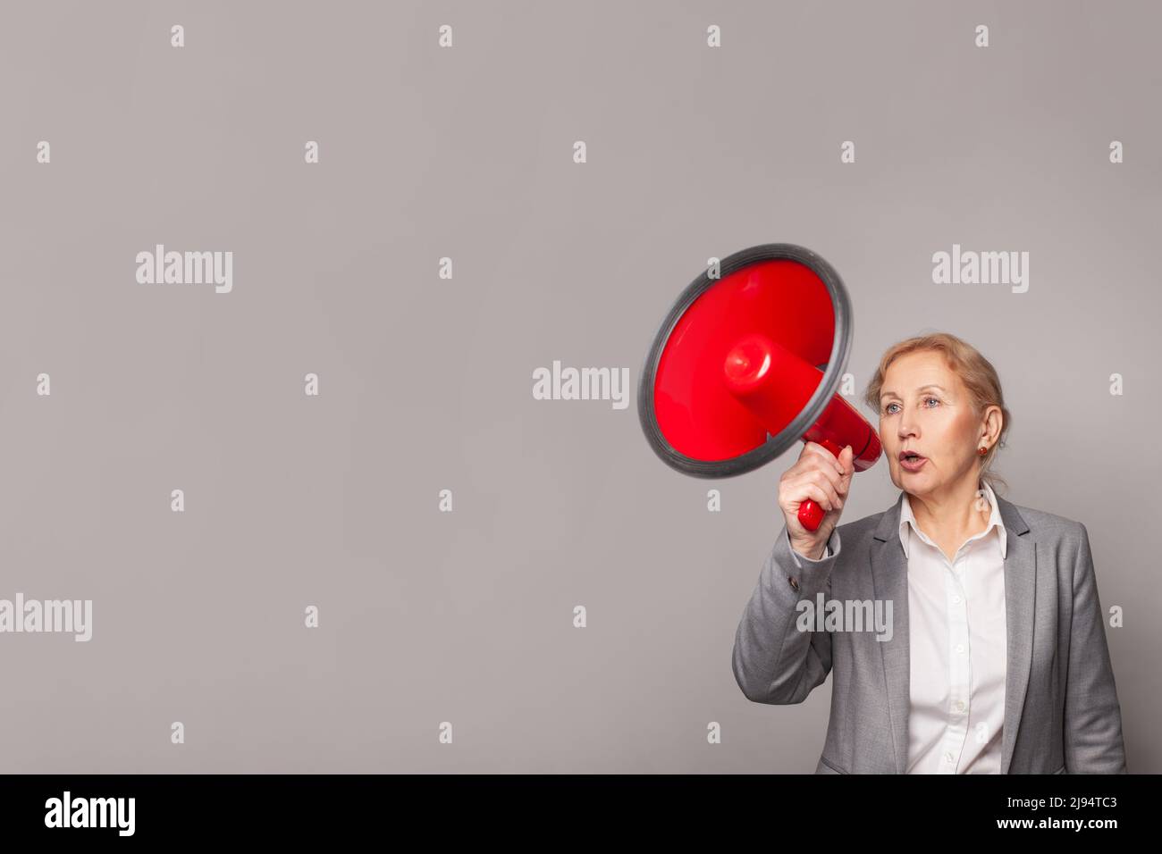 Mature woman yelling over megaphone Stock Photo - Alamy