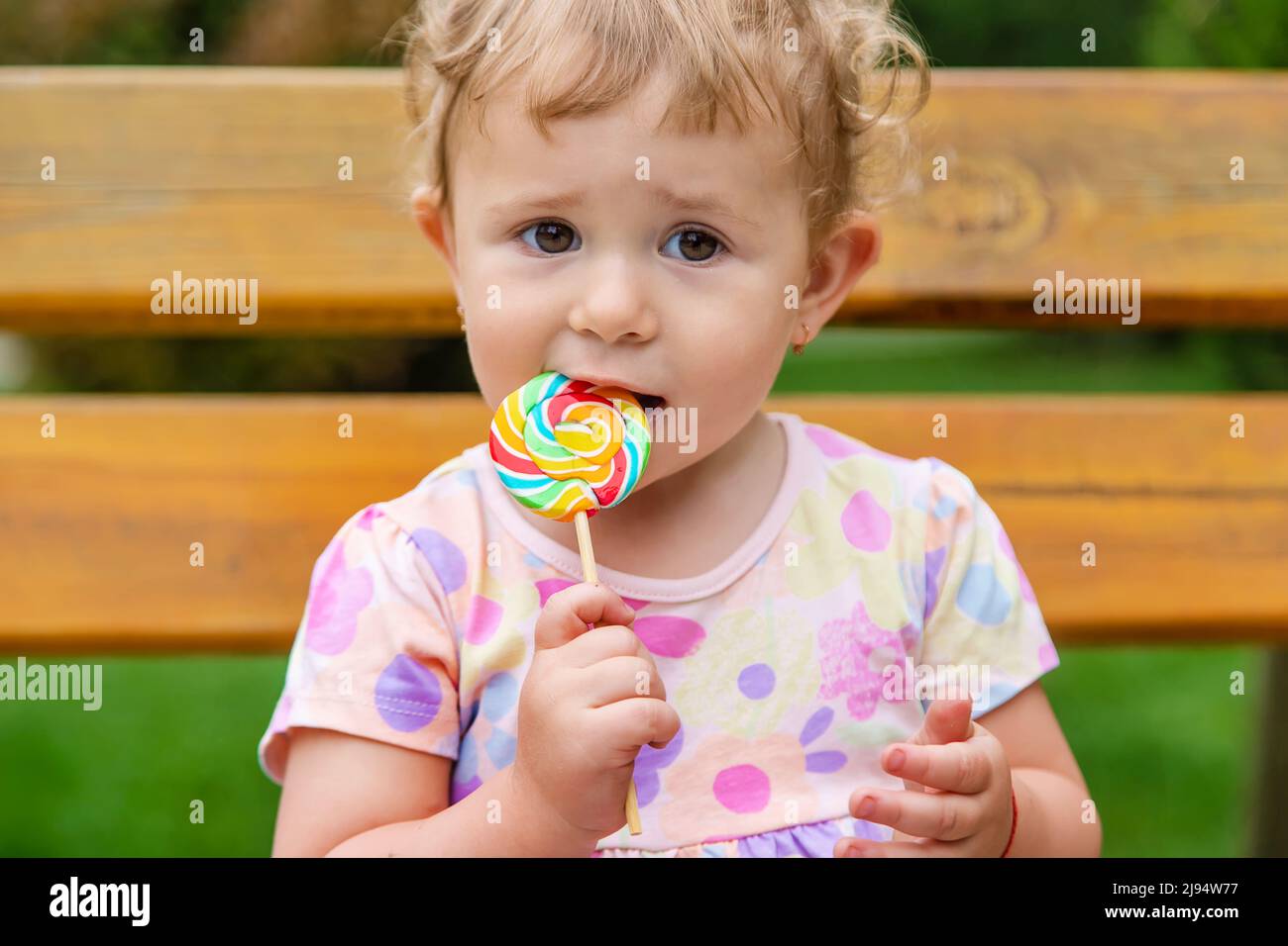 Baby eats a lollipop in the park. Selective focus Stock Photo - Alamy