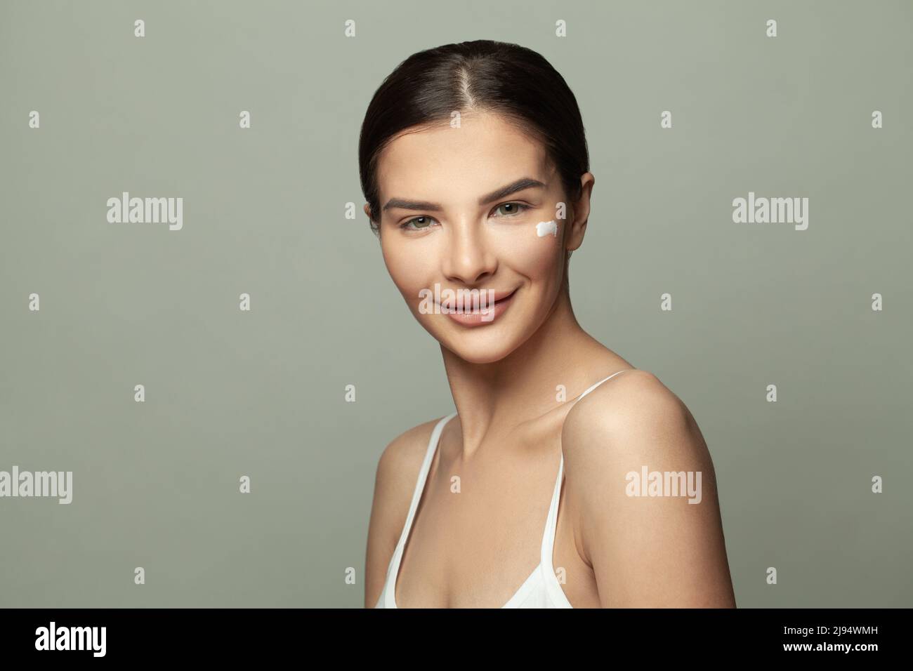 Attractive spa model woman with white cream on clean perfect skin on ...