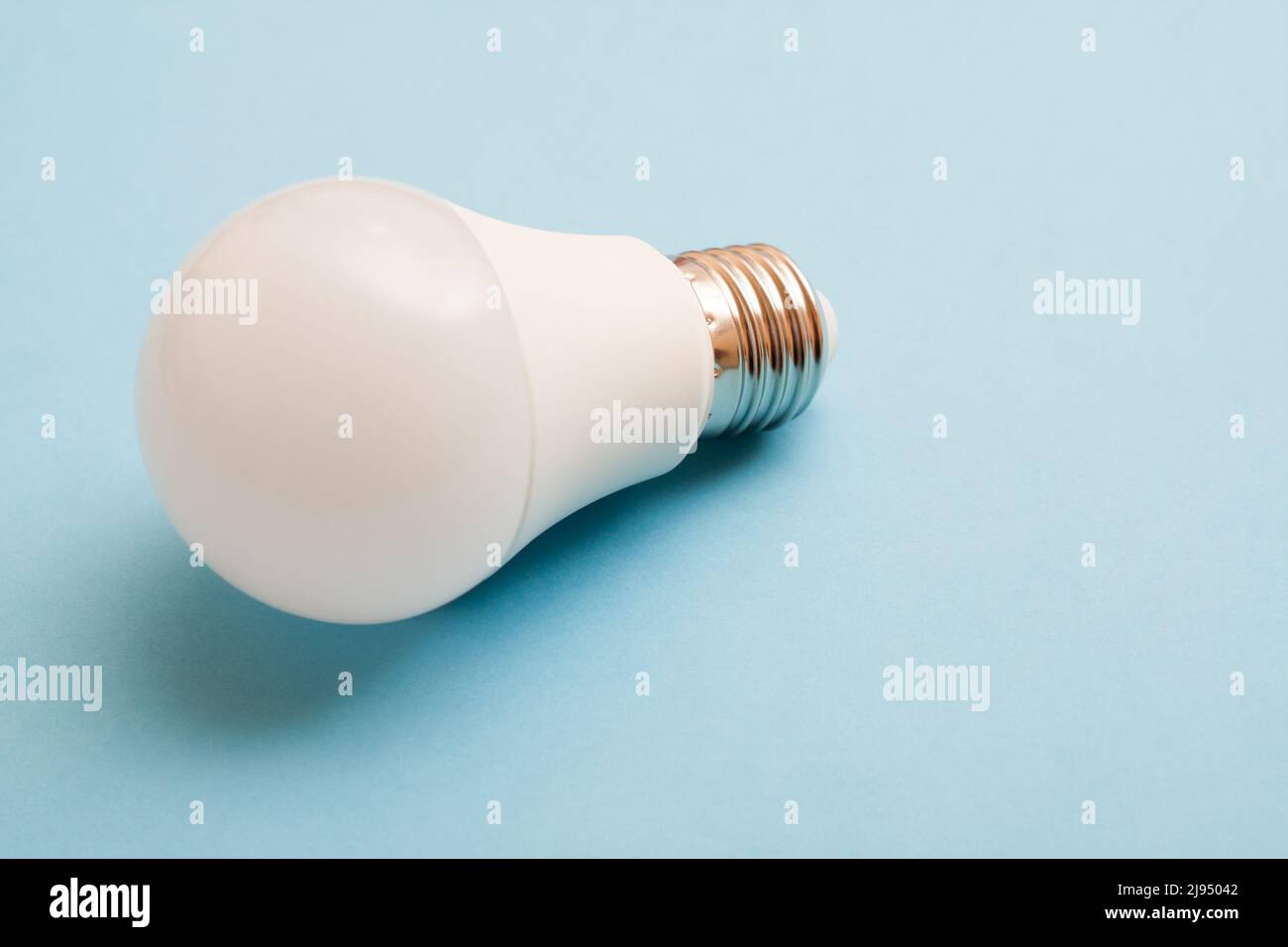 White economy light bulb on bue background with free copy paste space ...