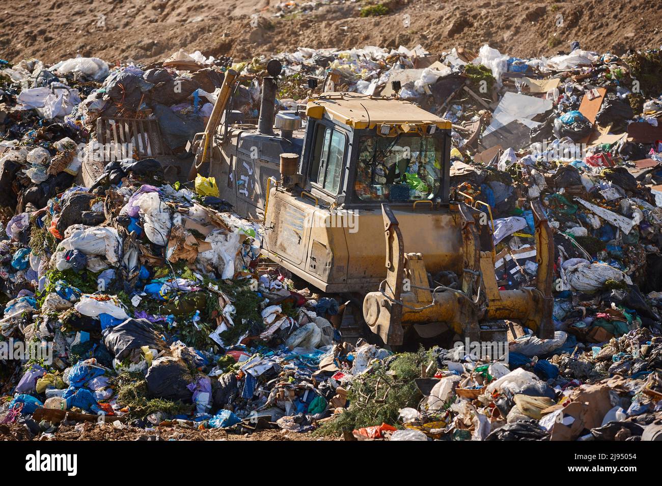 Heavy machinery shredding garbage in an open air landfill. Waste Stock ...