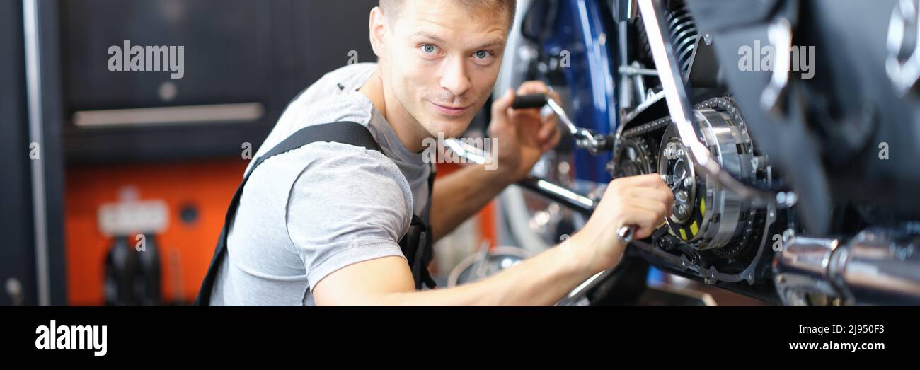 Male mechanic in a garage repairing a motorcycle Stock Photo - Alamy