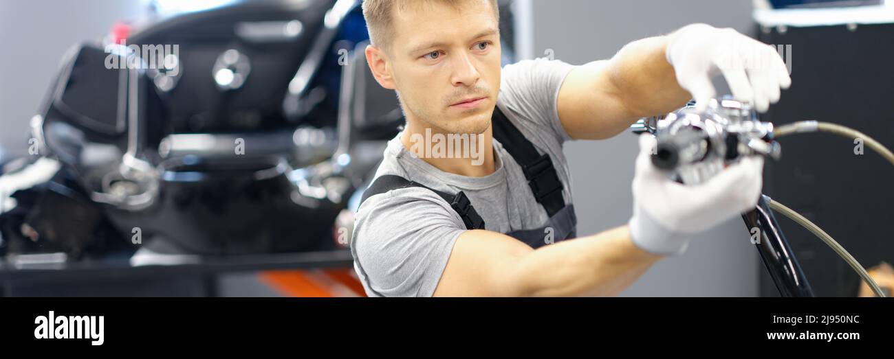 A male racer in a garage changes parts of a motorcycle Stock Photo - Alamy