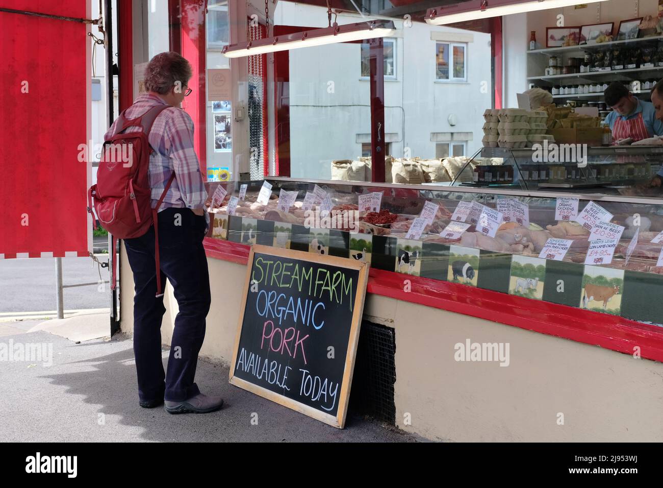 A person looking in a butchers shop window Stock Photo - Alamy