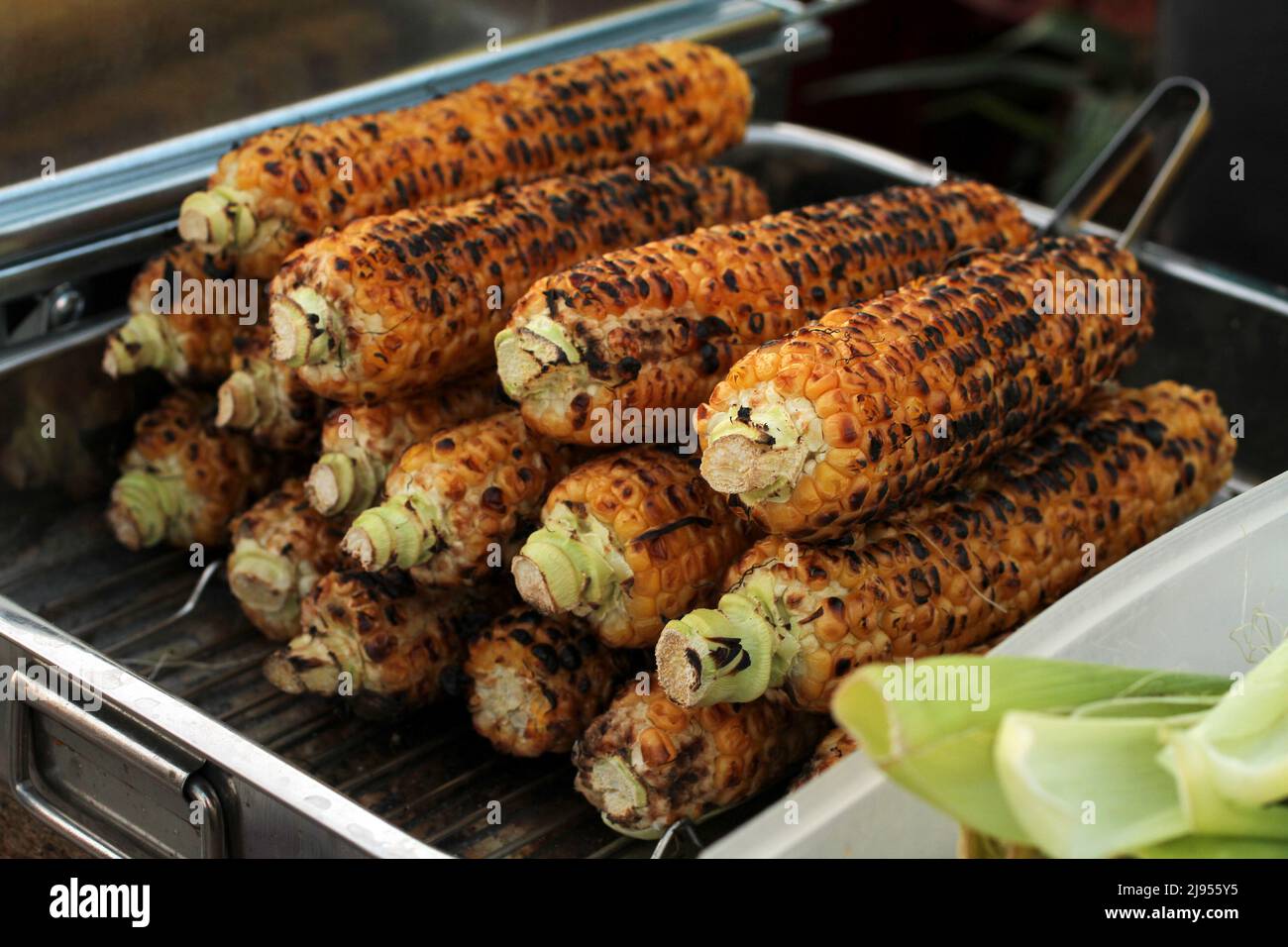 Roasted corn-cobs on brazier grid at the street. Closeup. Day light ...