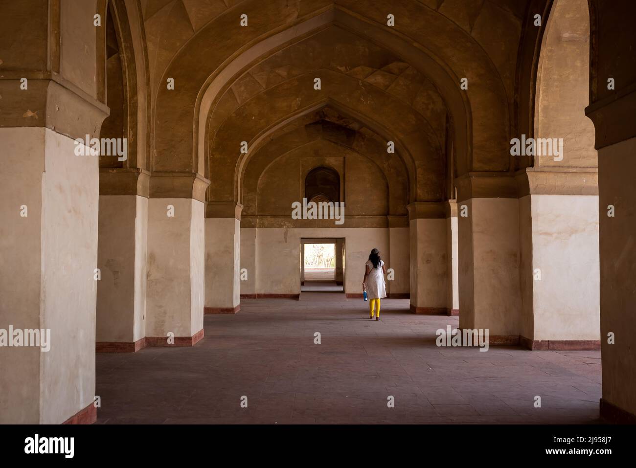 A lone girls walking along the corridors of Akbar's tomb at Sikandara ...