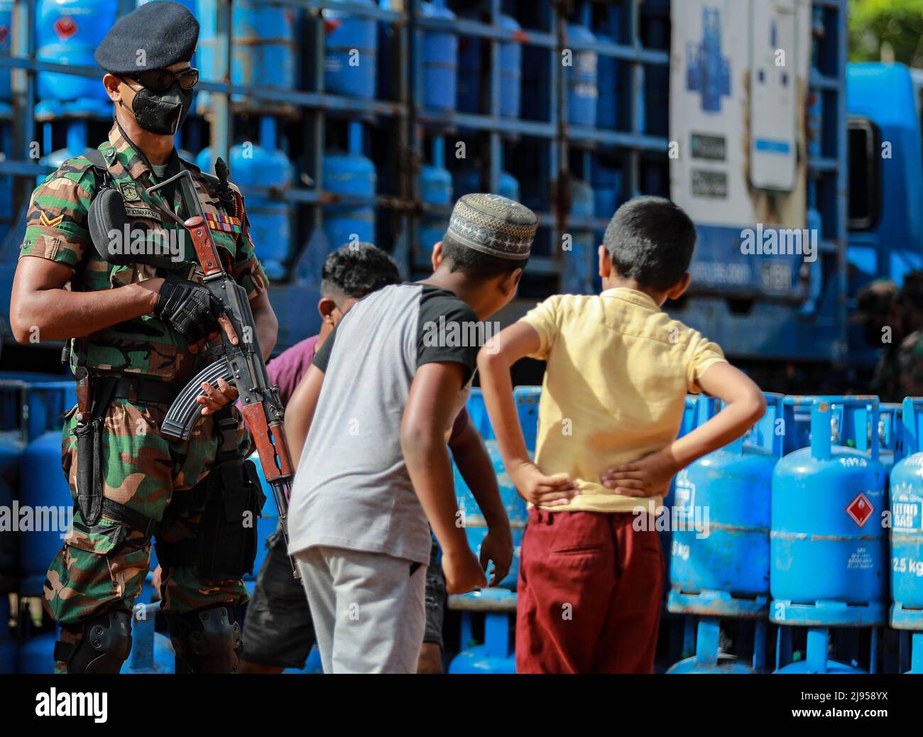 Soldiers stand guard as people queue to buy liquefied petroleum hi-res ...
