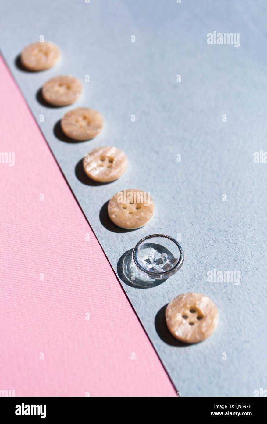 A row of buttons, one of them special, lies on a blue and pink ...