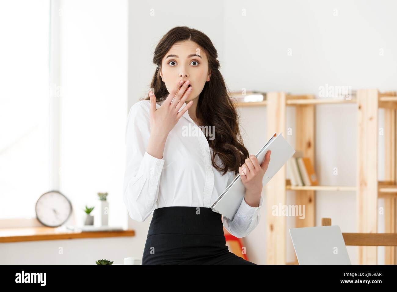 Shocked young business woman surprised by reading unexpected news in ...