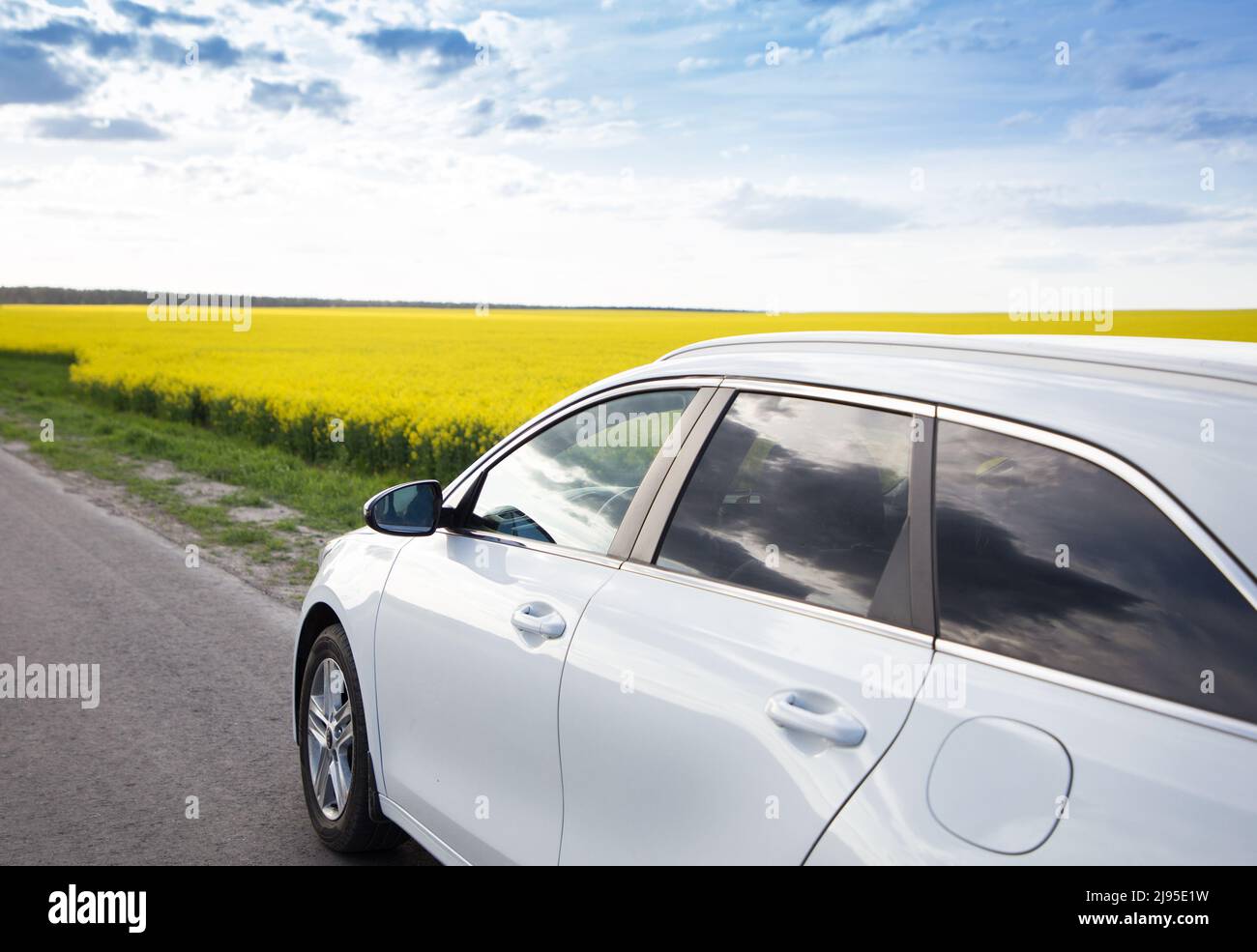travelling by car. In spring or summer, a white car drives along an ...