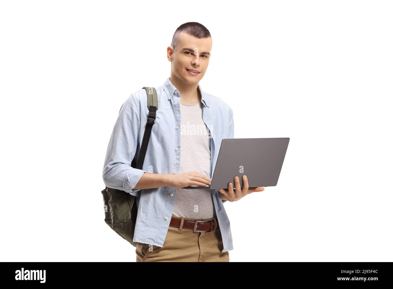 Smiling male student standing and using a laptop computer isolated on ...