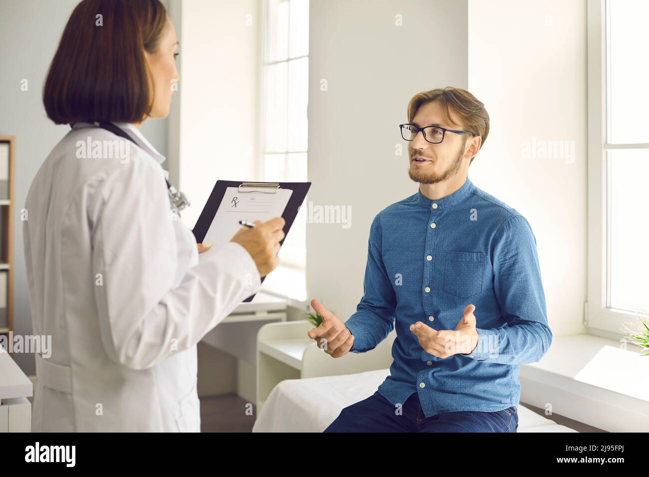 Young patient having conversation with physician during medical checkup ...