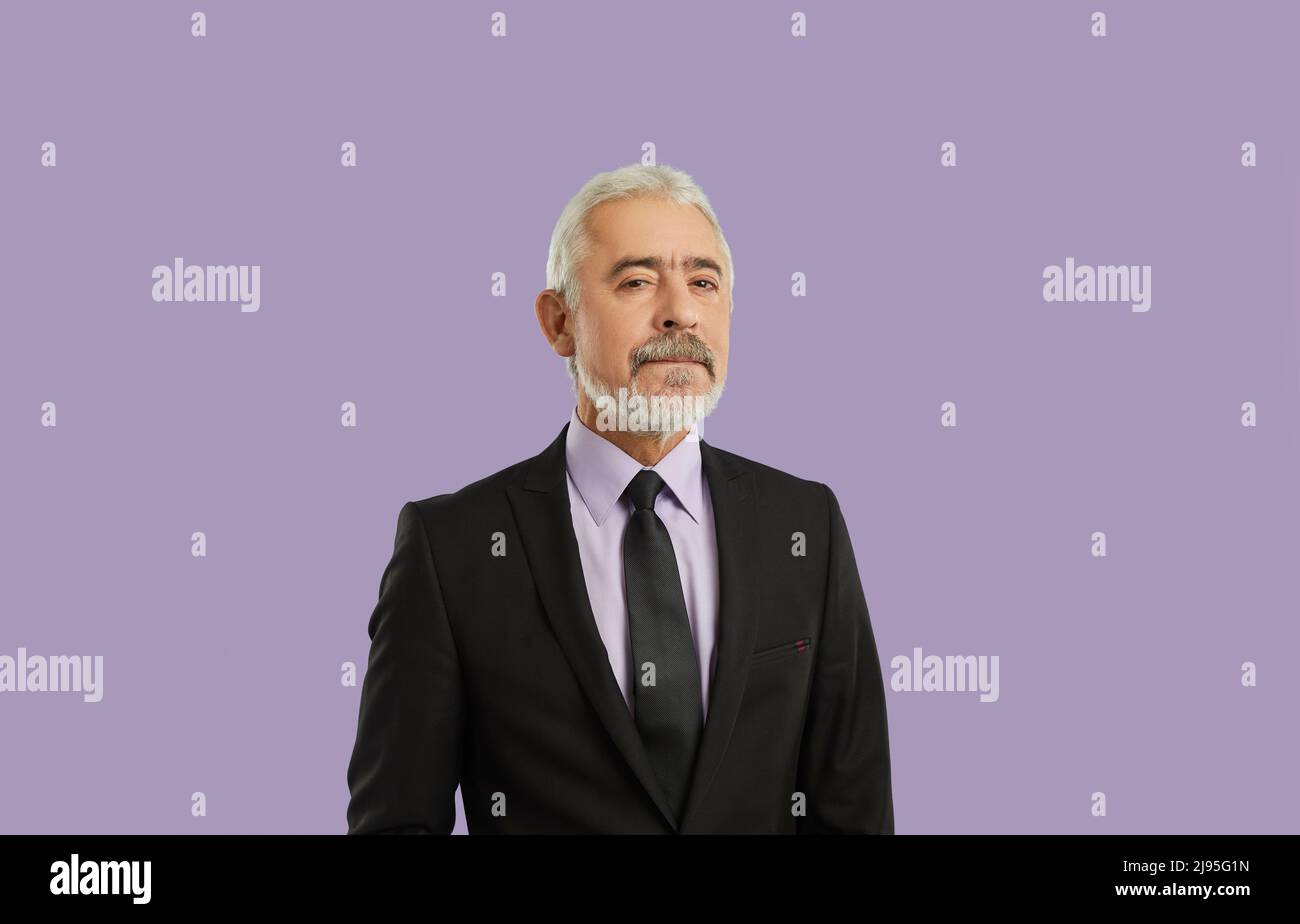 Portrait of serious and confident senior businessman isolated on pastel ...