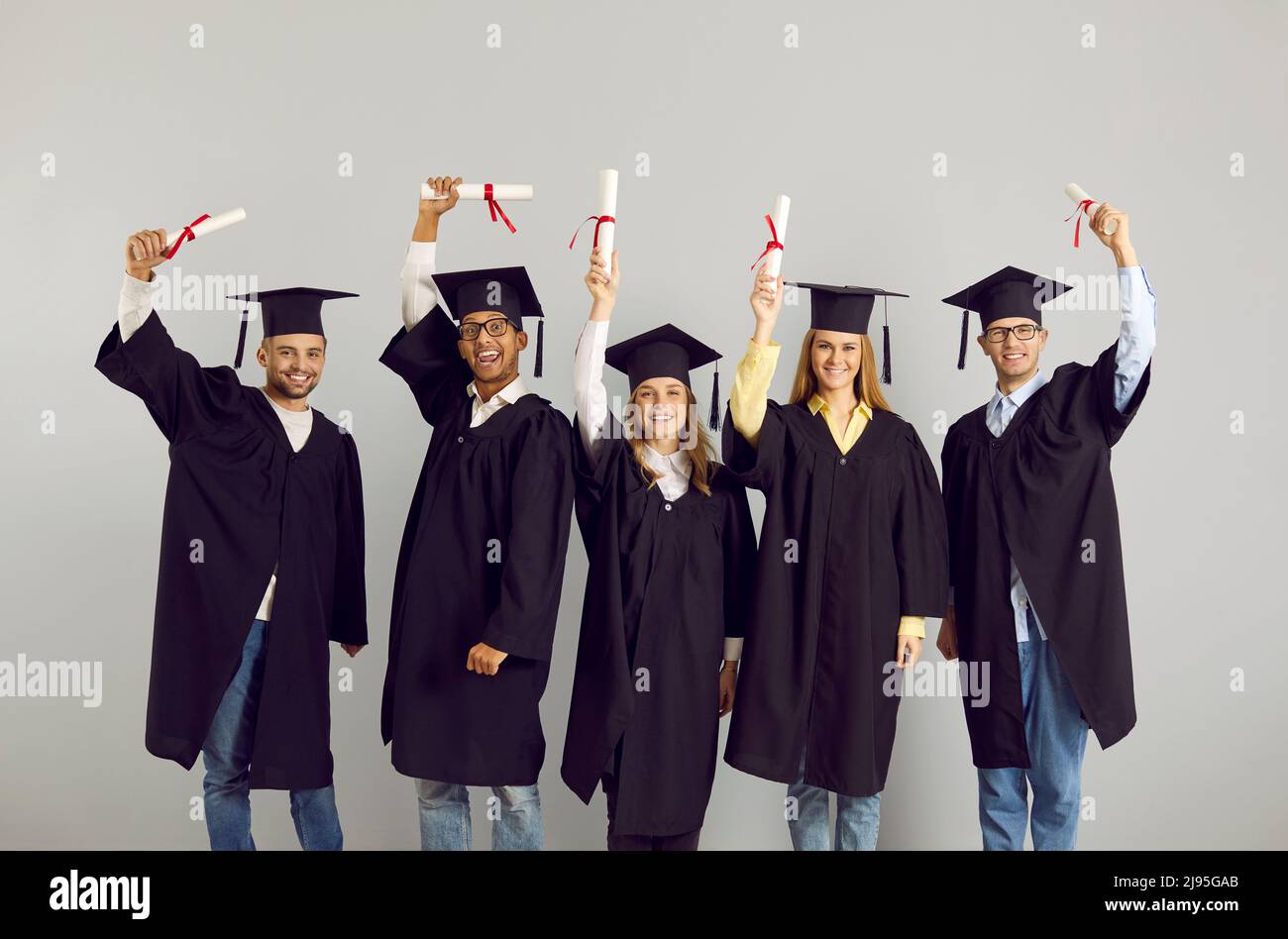 Portrait of happy students in robes excited with graduation Stock Photo ...