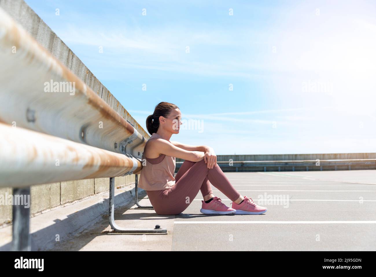Fit sporty woman sitting, resting after working out outside Stock Photo ...