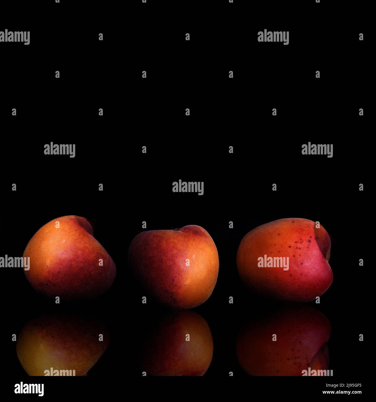 three peaches with reflections on a table with a black background Stock ...