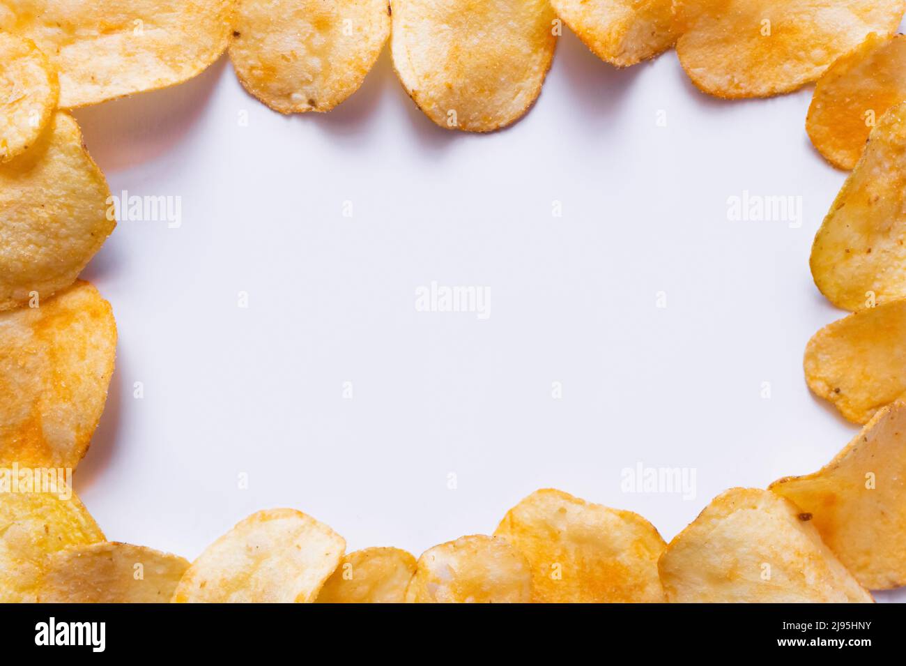 flat lay view of delicious, fried and salty potato chips on white Stock ...