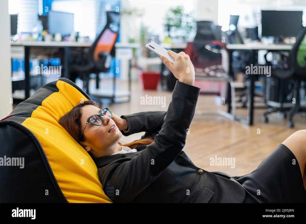 A business woman in a suit is resting while sitting in a comfortable ...