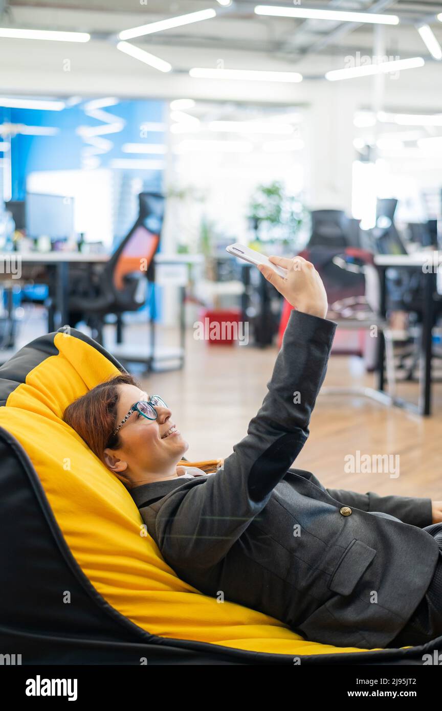 A business woman in a suit is resting while sitting in a comfortable ...
