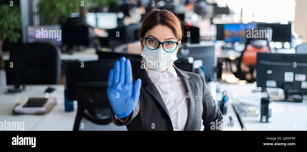 Female office manager in a medical mask and gloves. A woman in a suit ...