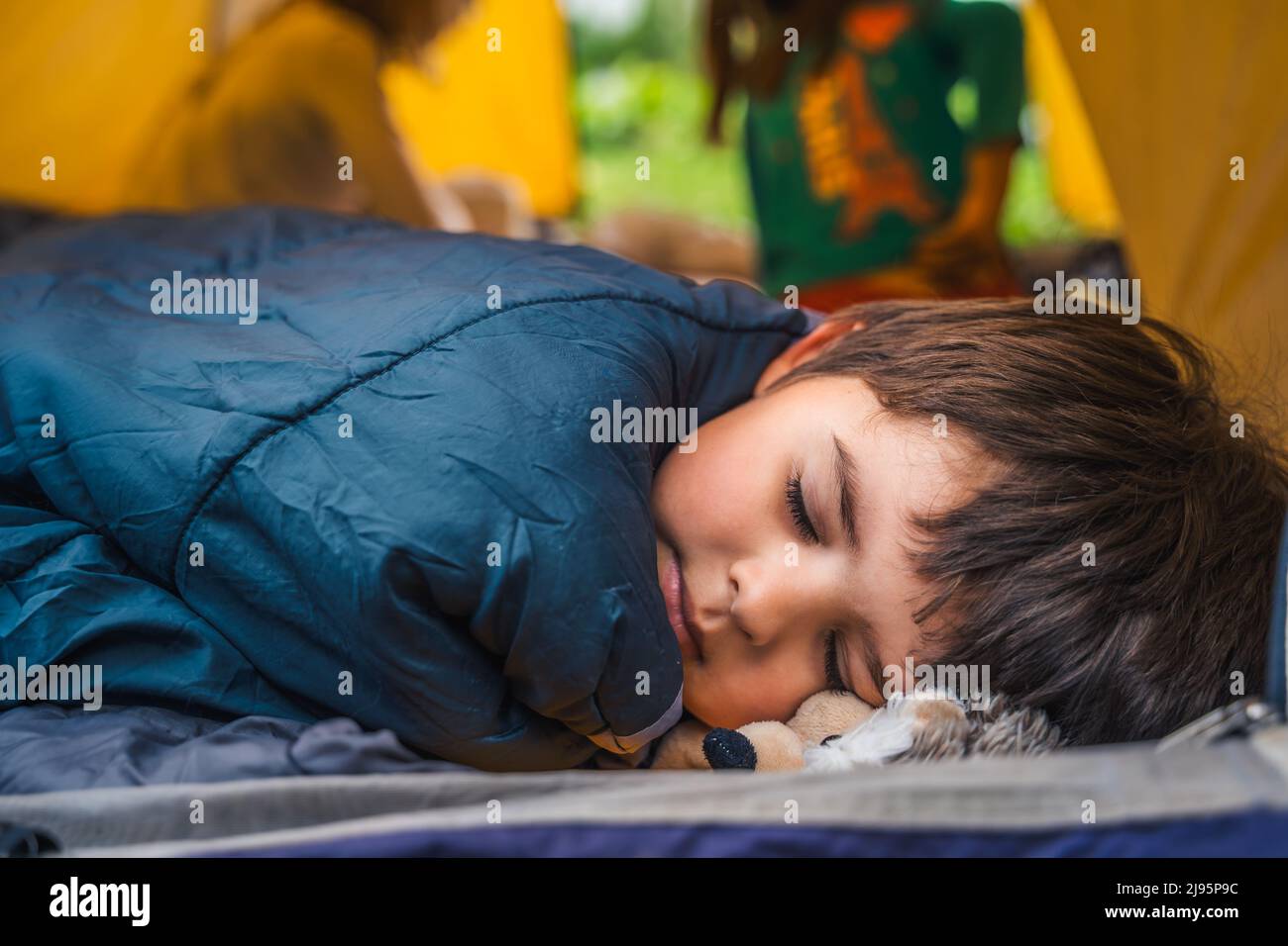 Small children, kids, boy play, sleep in sleepig bag in orange tourist ...